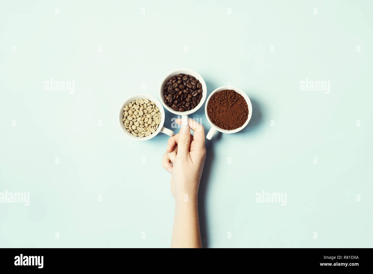 Different types of coffee - ground, grain and unroasted on blue pastel ...