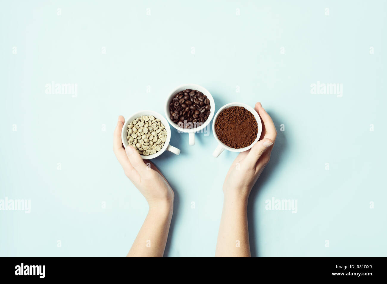 Different types of coffee - ground, grain and unroasted on blue pastel ...