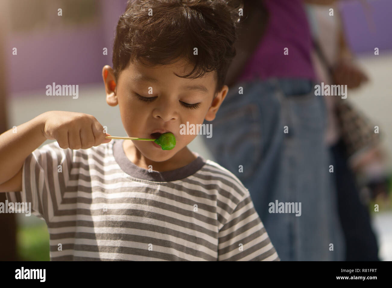 Asian boy eating a Ball plated dessert Stock Photo - Alamy