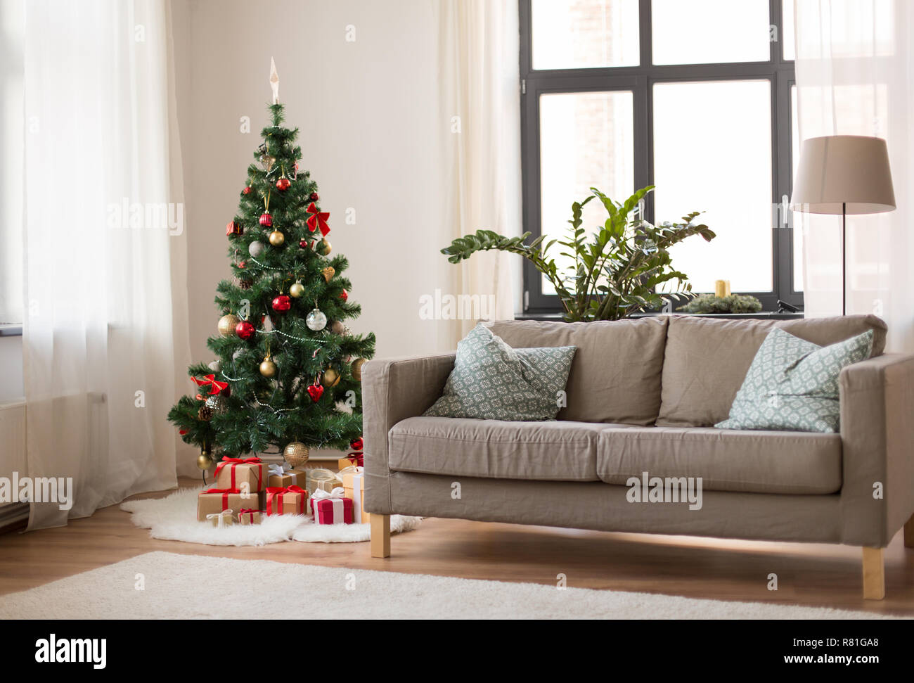christmas tree, gifts and sofa at cozy home Stock Photo - Alamy