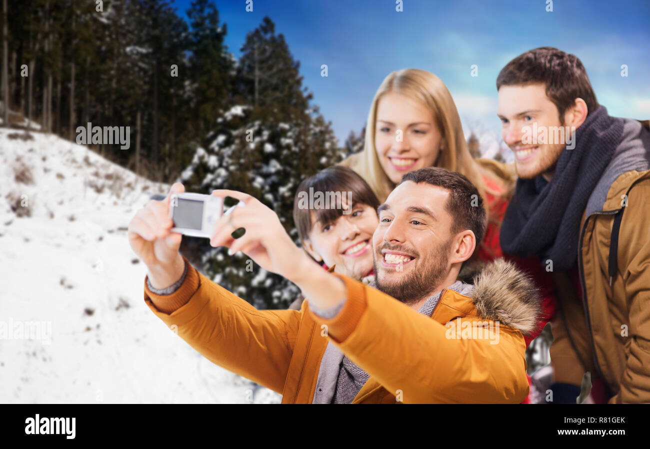 happy friends with camera over winter background Stock Photo - Alamy