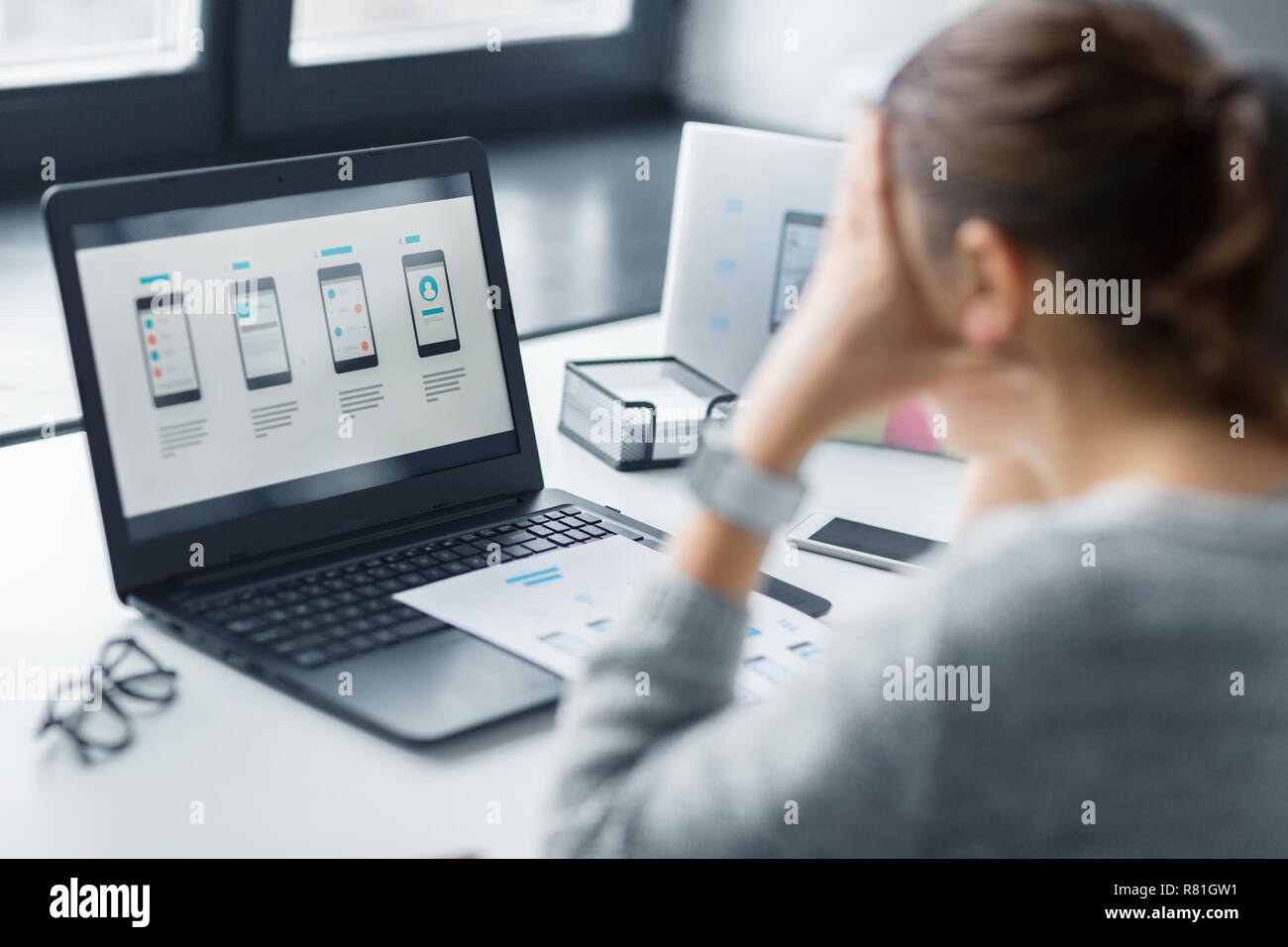 stressed designer with user interface on laptop Stock Photo - Alamy