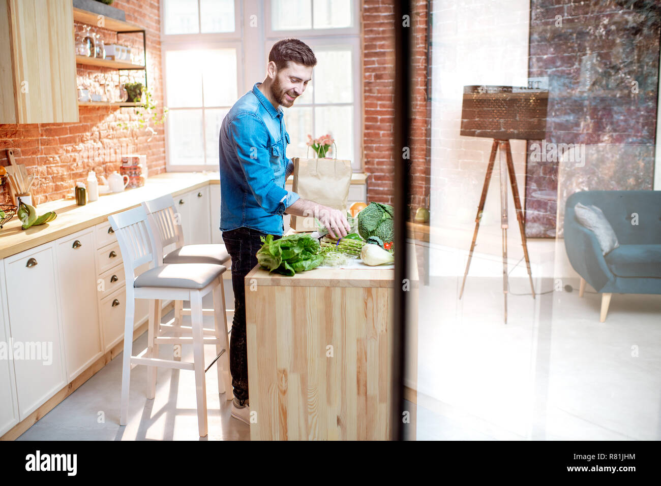 Man cooking healthy food standing on the kitchen of the beautiful loft ...