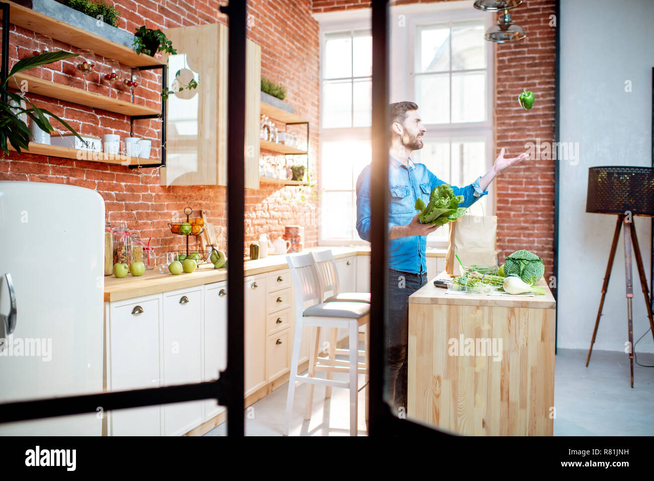 Man cooking healthy food standing on the kitchen of the beautiful loft ...