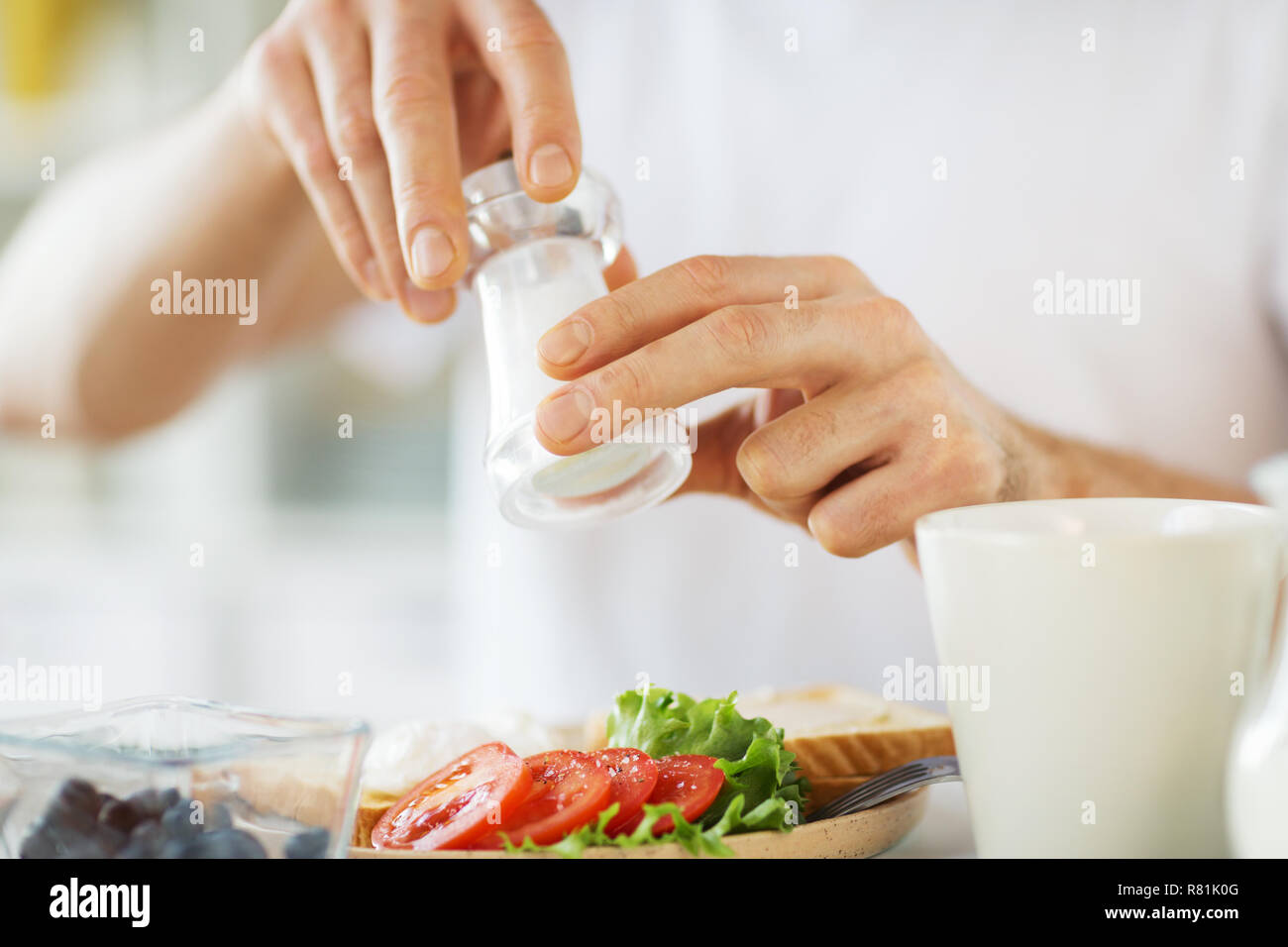 close up of male hands seasoning food by salt mill Stock Photo - Alamy