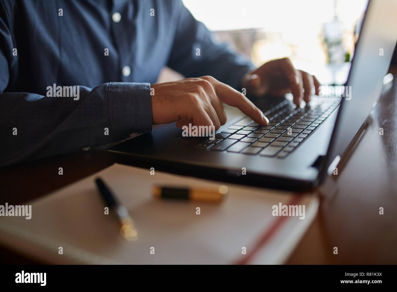 Close-up photo of caucasian male hands typing on laptop keyboard and ...