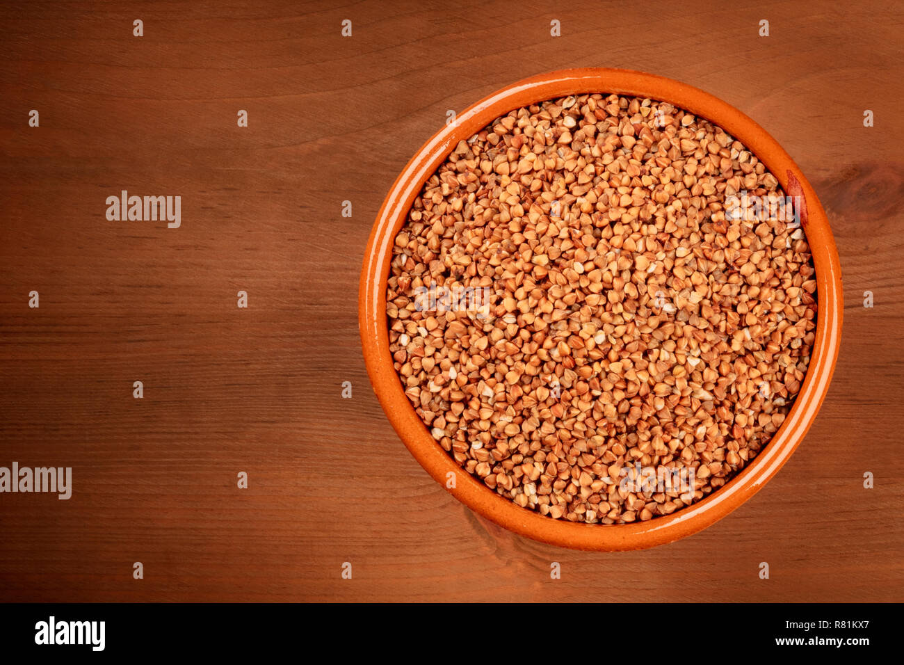 A photo of raw buckwheat in an earthenware bowl, shot from the top on a ...