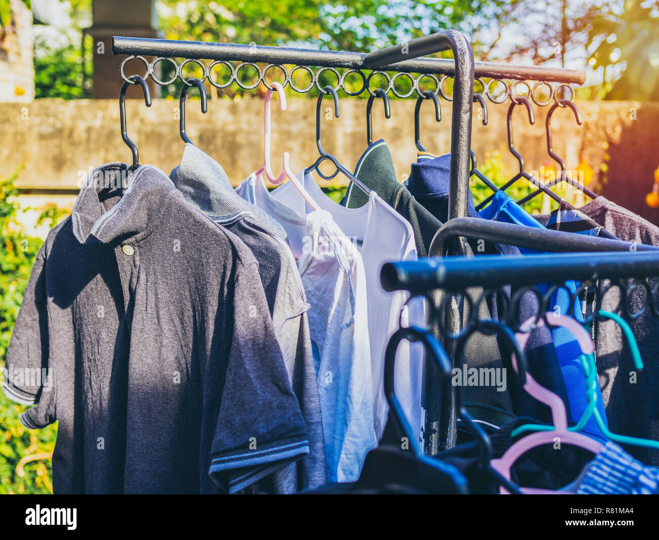 Many colors shirts on hanger are hanging on the clothesline with ...