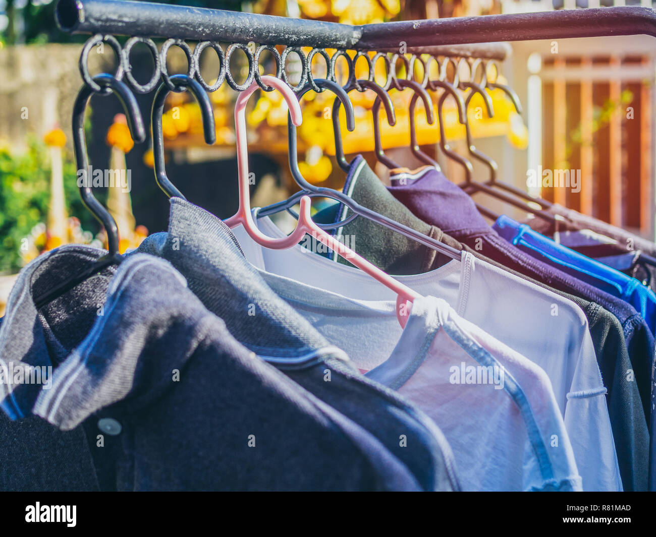 Many colors shirts on hanger are hanging on the clothesline with ...