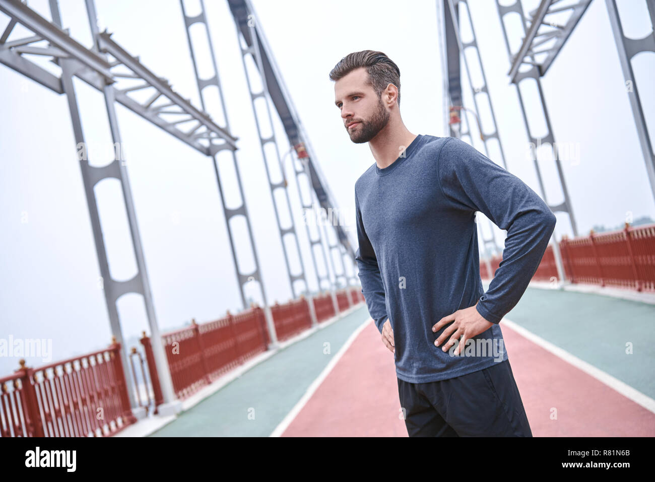 Serious about sport. Handsome young man in sports clothing looking ...
