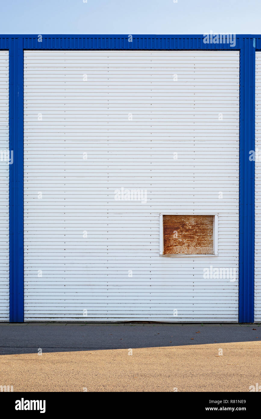 White Industrial warehouse wall in blue frame Stock Photo - Alamy