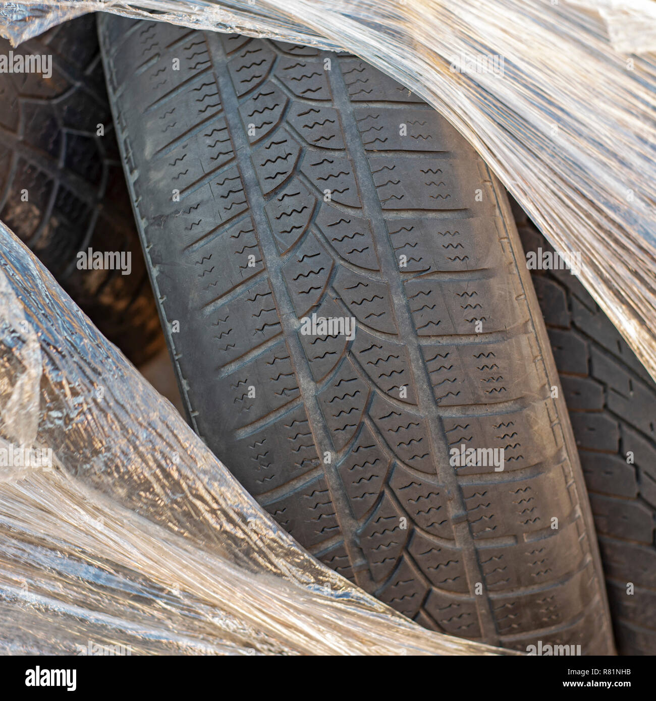 Worn out tires of heavy vehicles wrapped in plastic Stock Photo - Alamy