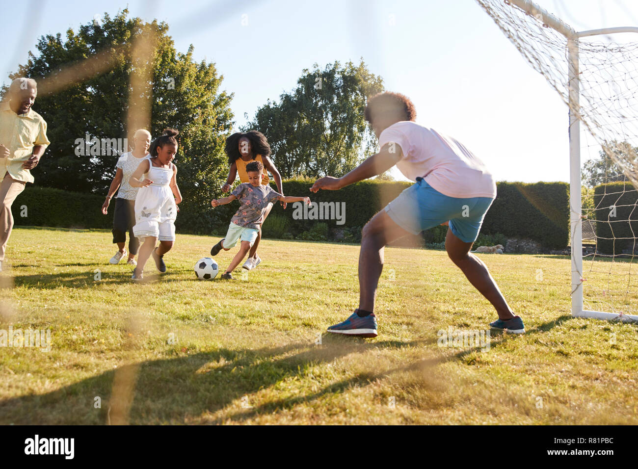 Multi generation black family playing football in a garden Stock Photo ...