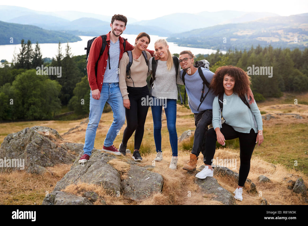 Multi ethnic group of five young adult friends standing at the summit ...