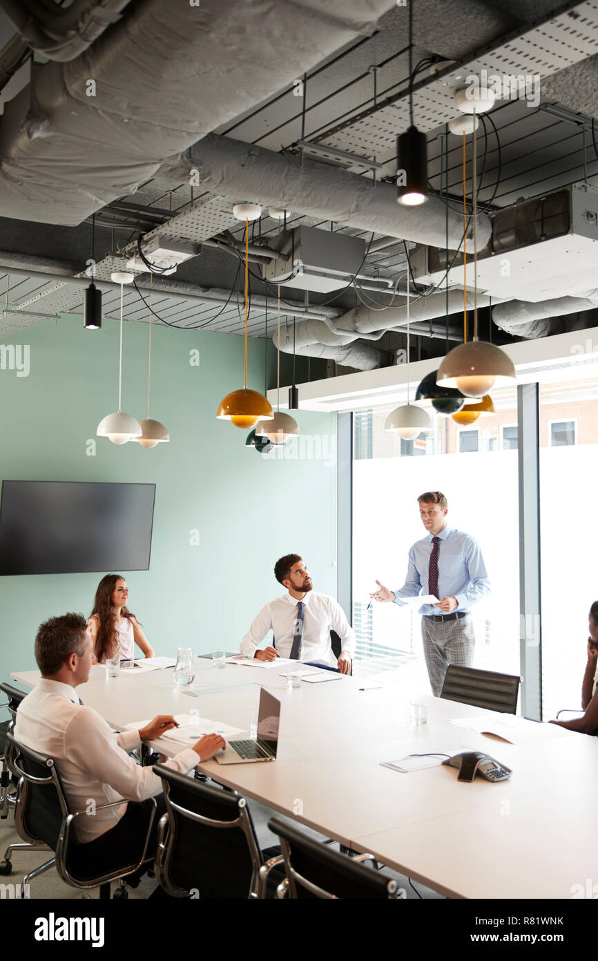 Businessman Giving Boardroom Presentation To Colleagues In Meeting Room ...
