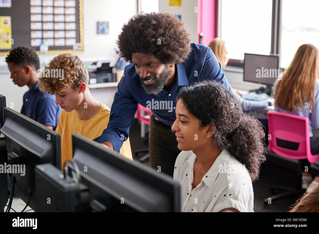 Male Teacher Helping Teenage Female High School Student Working In ...