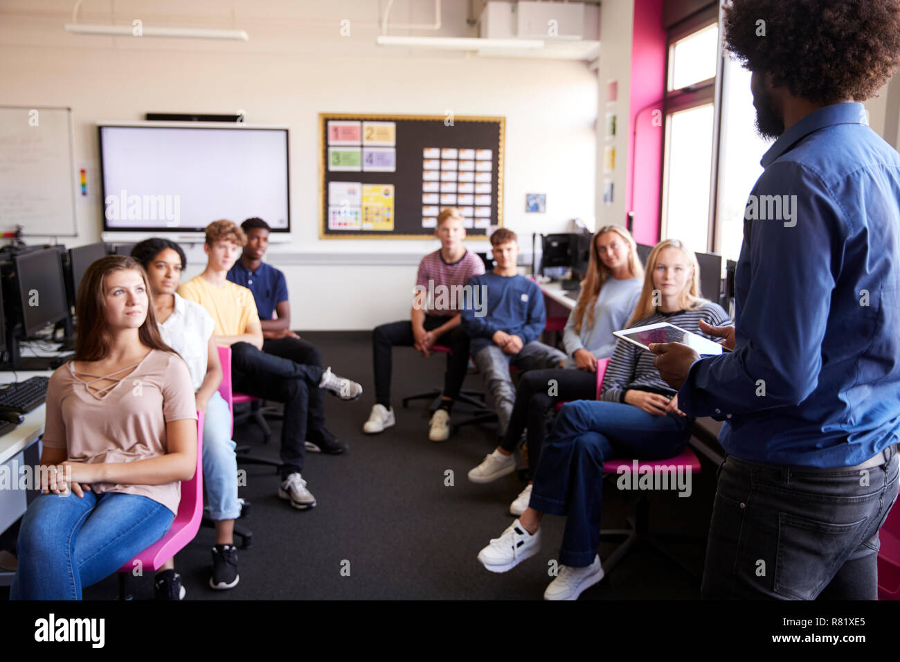 Male Teacher With Digital Tablet Teaching High School Computer Class ...
