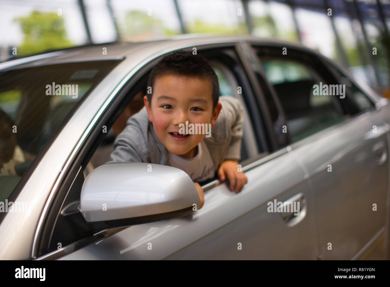 Young boy sticking his head out of the window of a car Stock Photo - Alamy