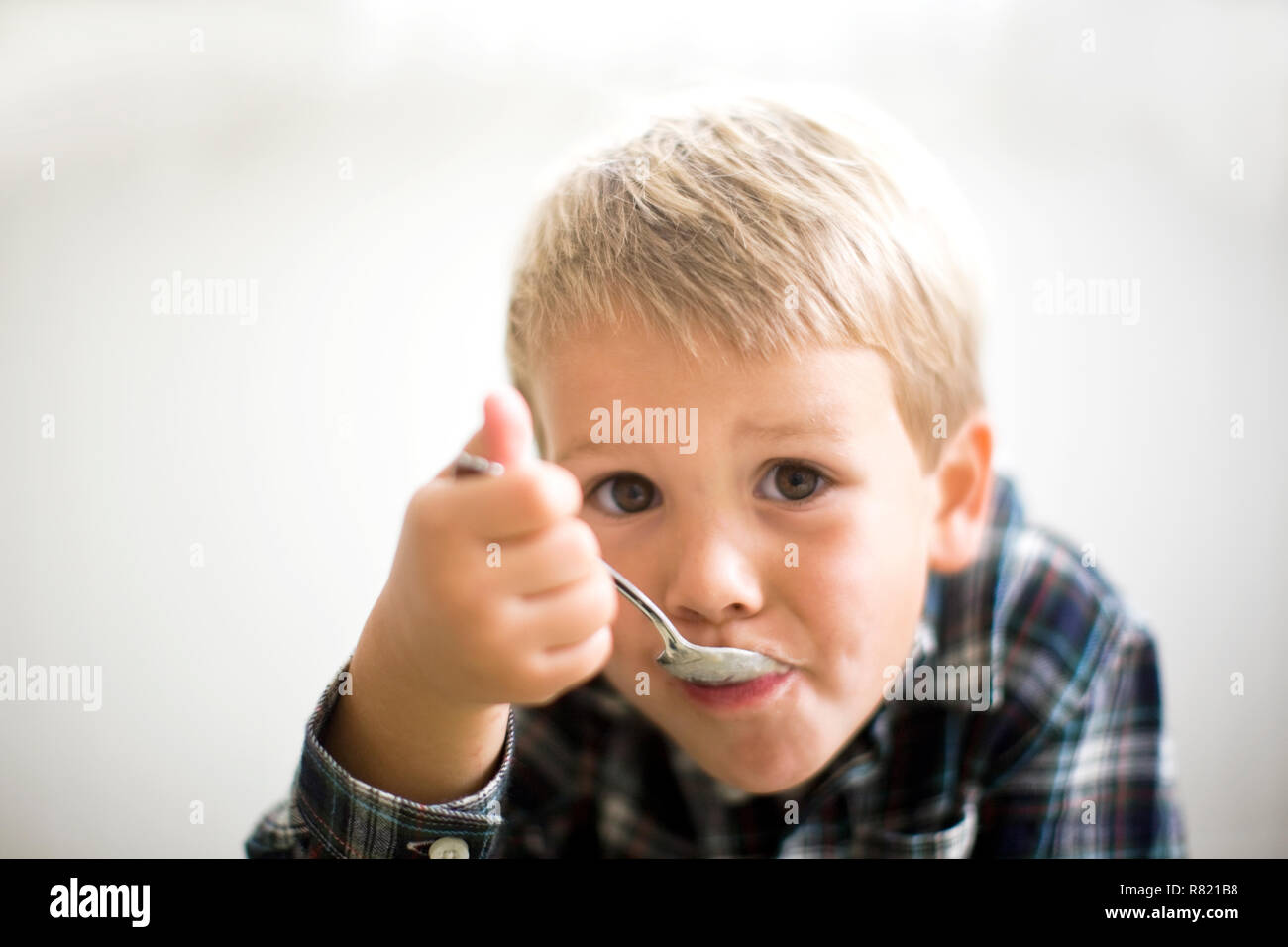 Portrait of a young boy eating Stock Photo - Alamy