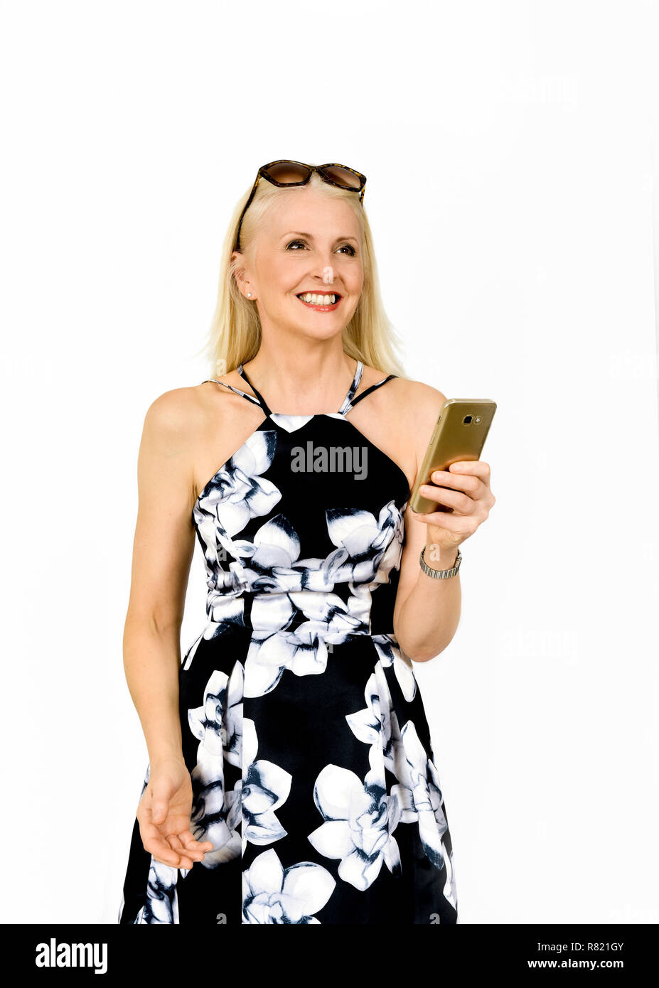 Attractive happy woman in pretty dress looking up after reading a text ...