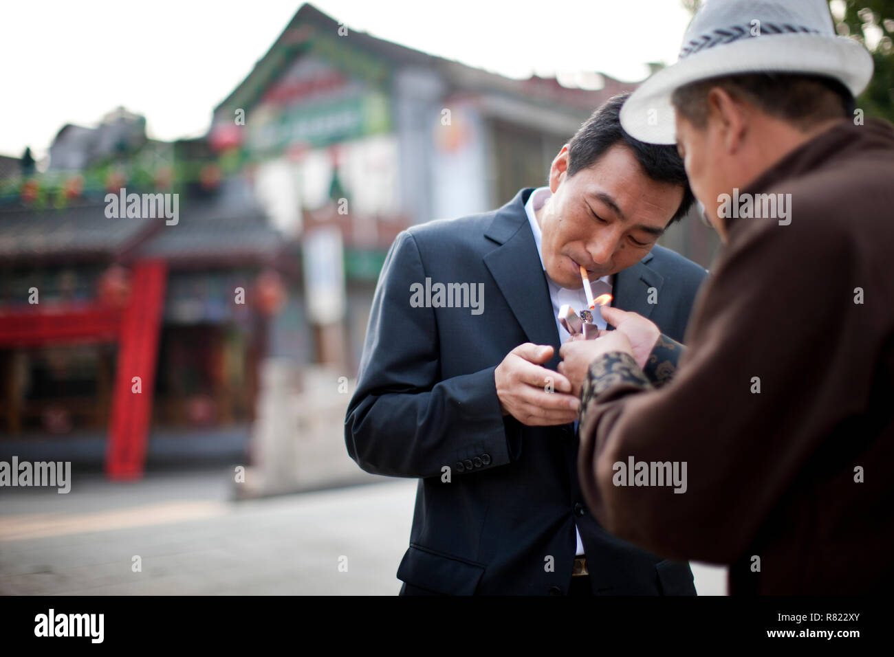 Man receiving a light from a stranger on the street Stock Photo - Alamy
