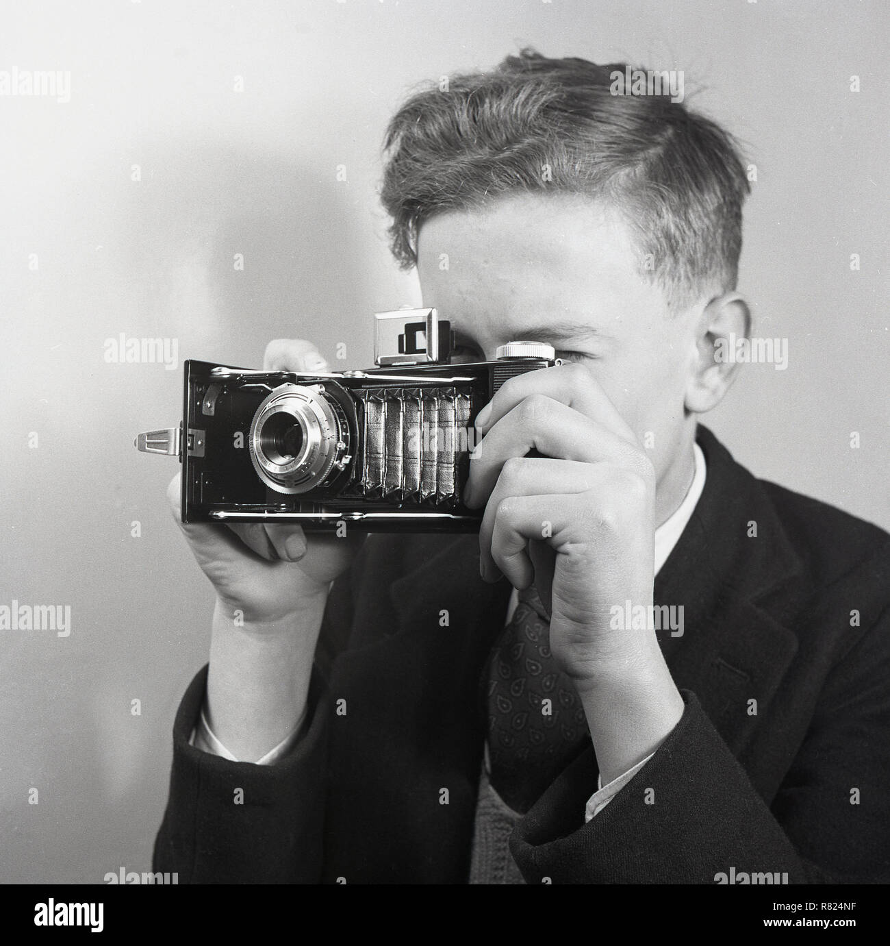 1950s, historical, film photography, teenager boy using a film camera ...
