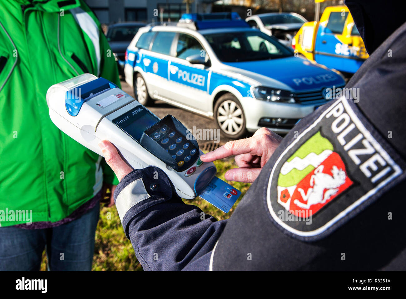Police officer collecting an on-the-spot fine with a card reader ...