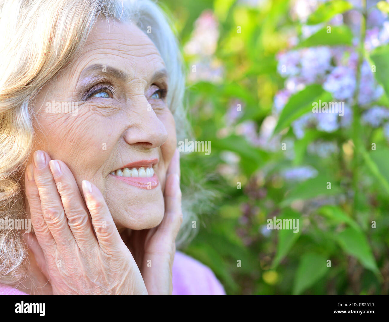 Portrait of beautiful senior woman posing near blooming tree Stock ...
