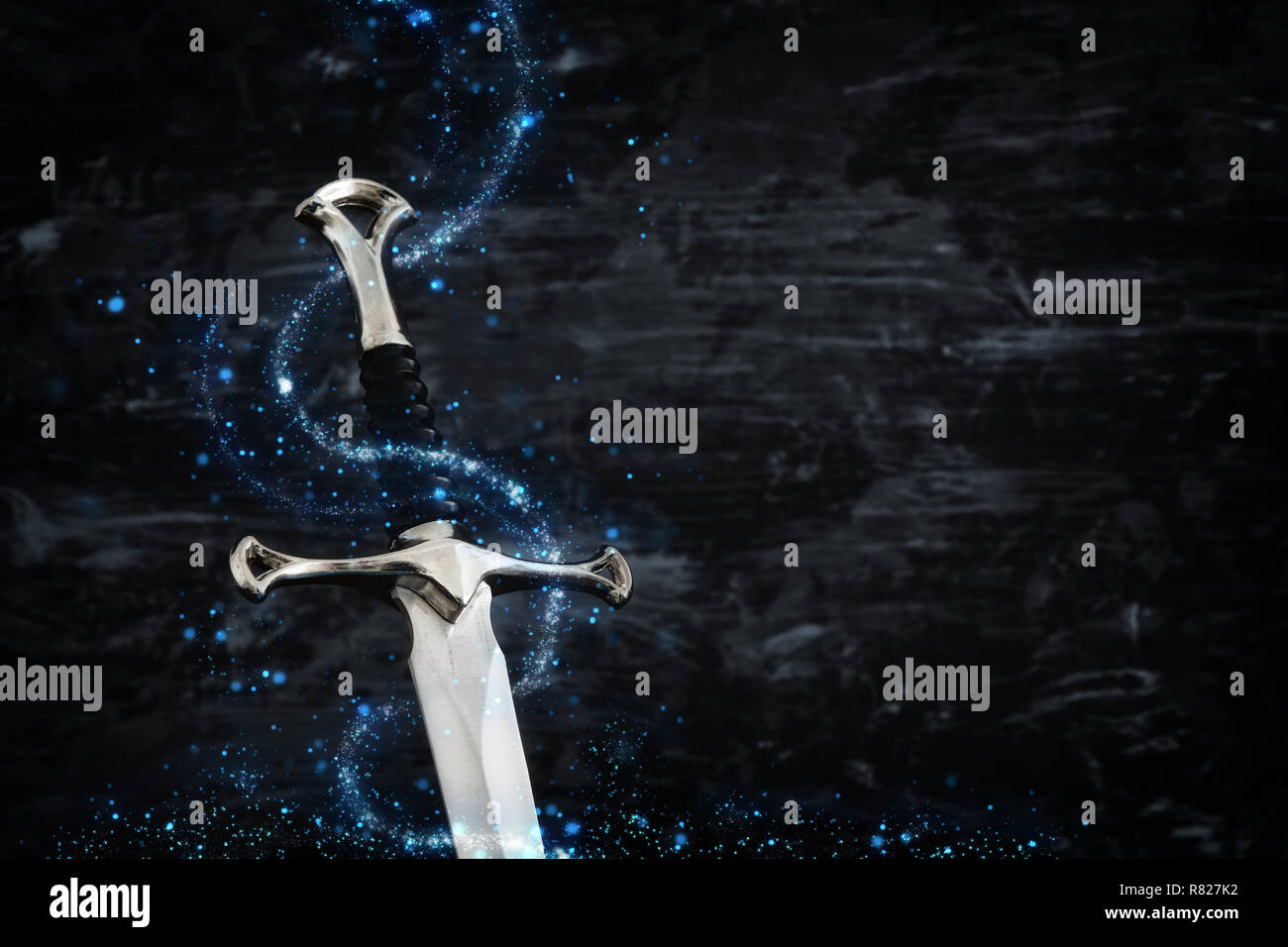 low key image of silver sword with magical lights. fantasy medieval ...