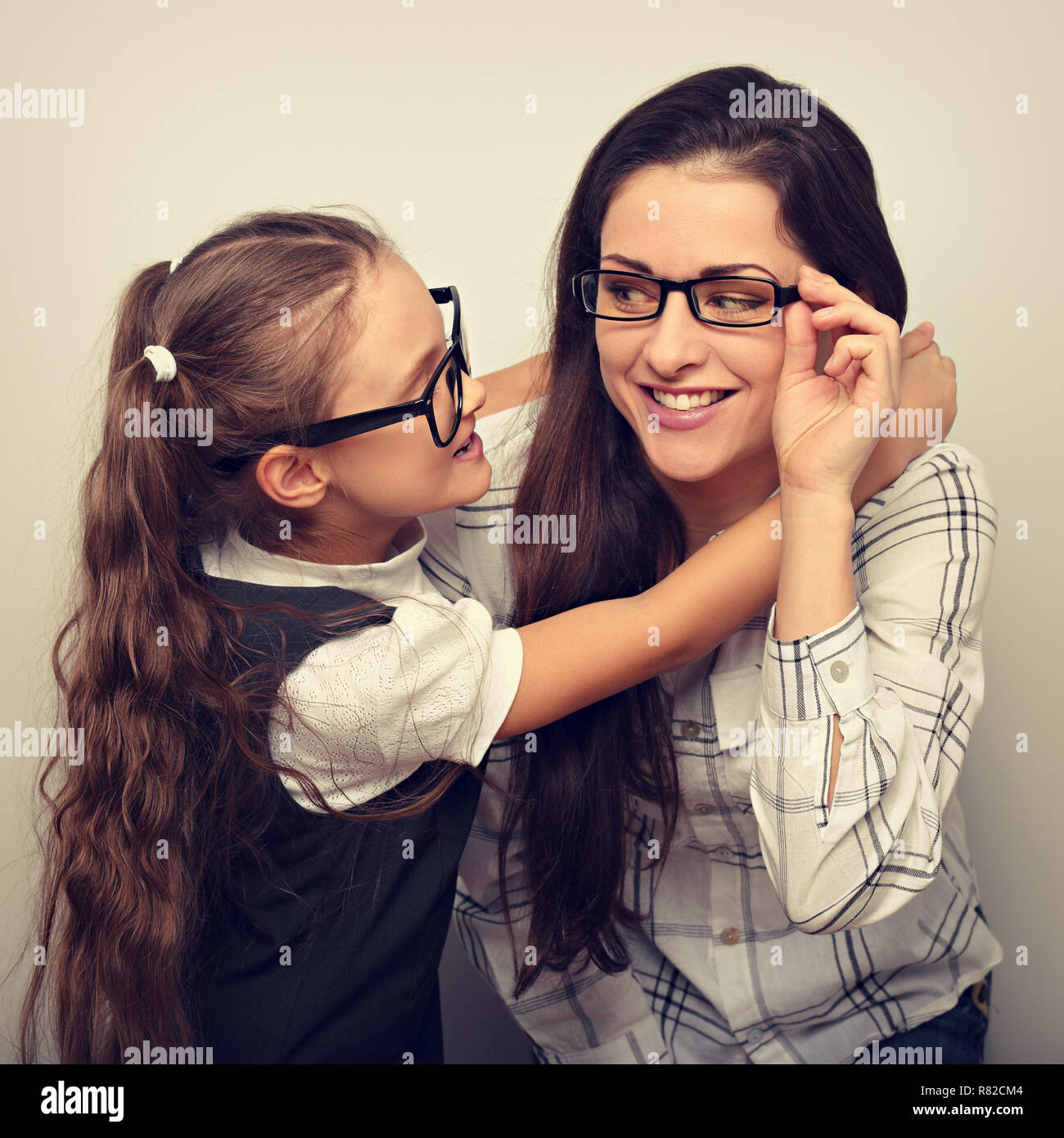 Happy surprising mother and excite kid in fashion glasses looking each ...