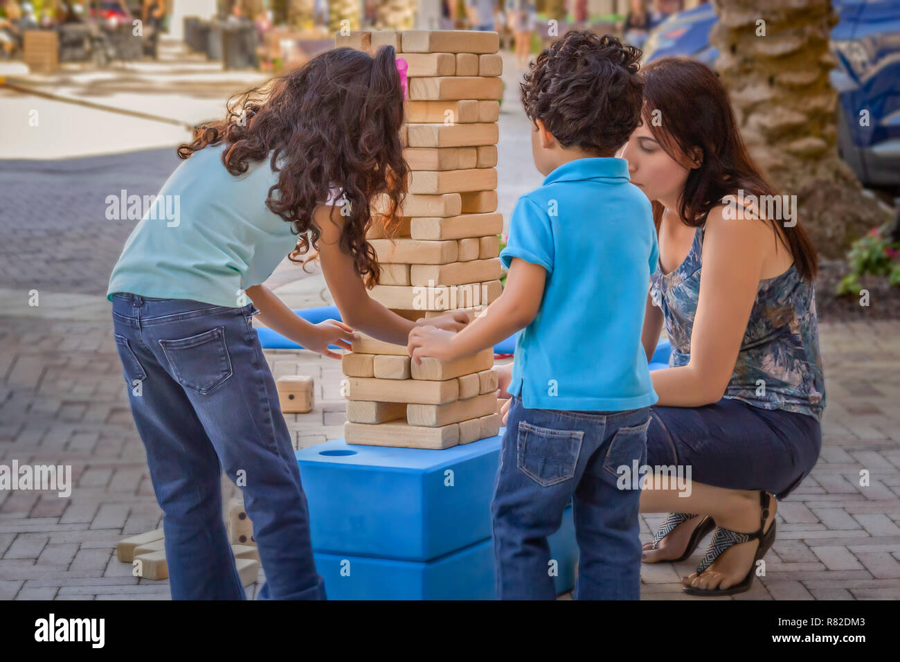 The young girl is careful not to knock down the wooden large size ...