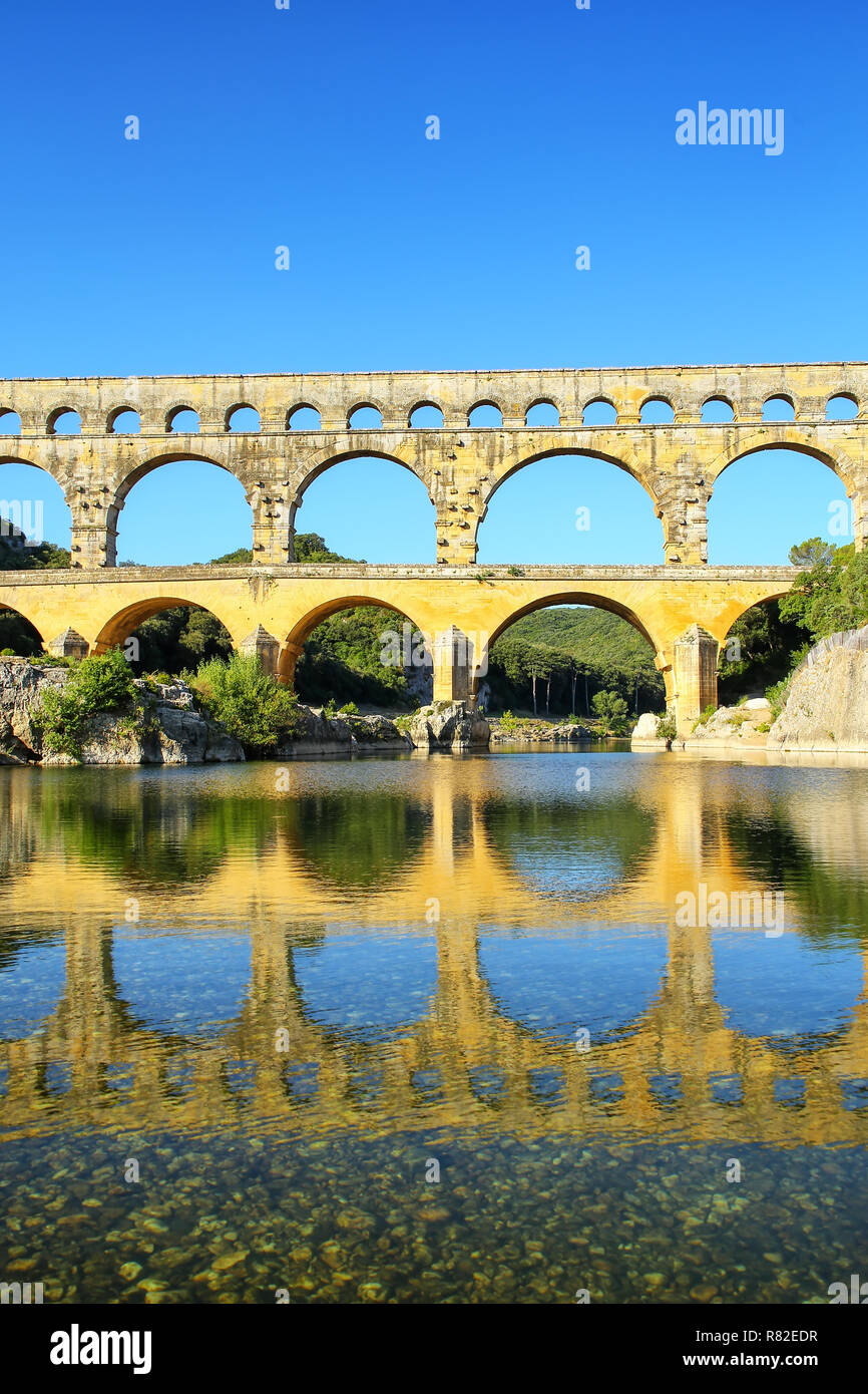 Aqueduct Pont du Gard reflected in Gardon River, southern France. It is ...