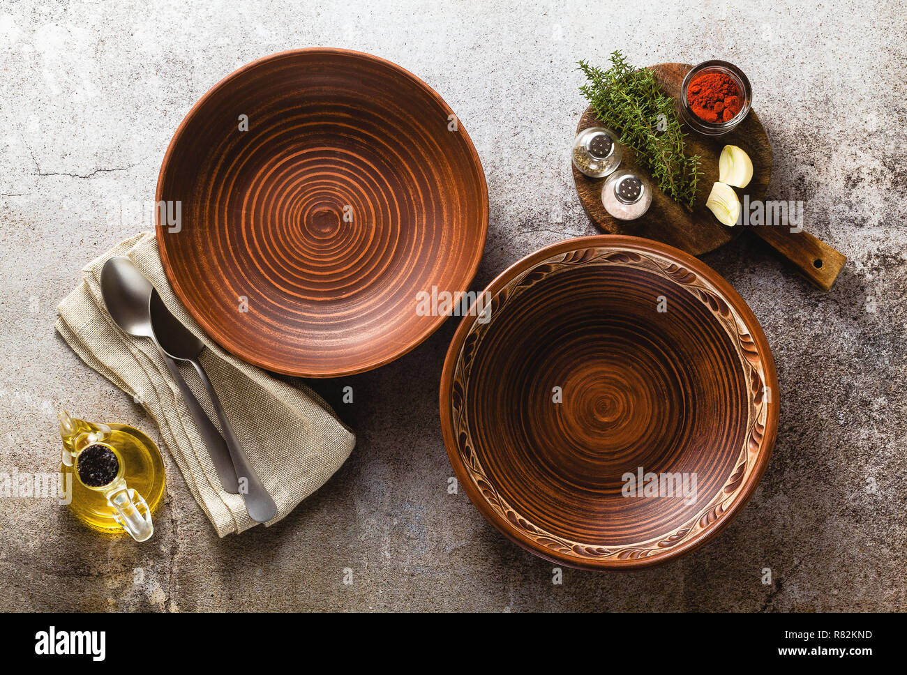 dishes of red clay on a stone table with spices. handmade tableware ...