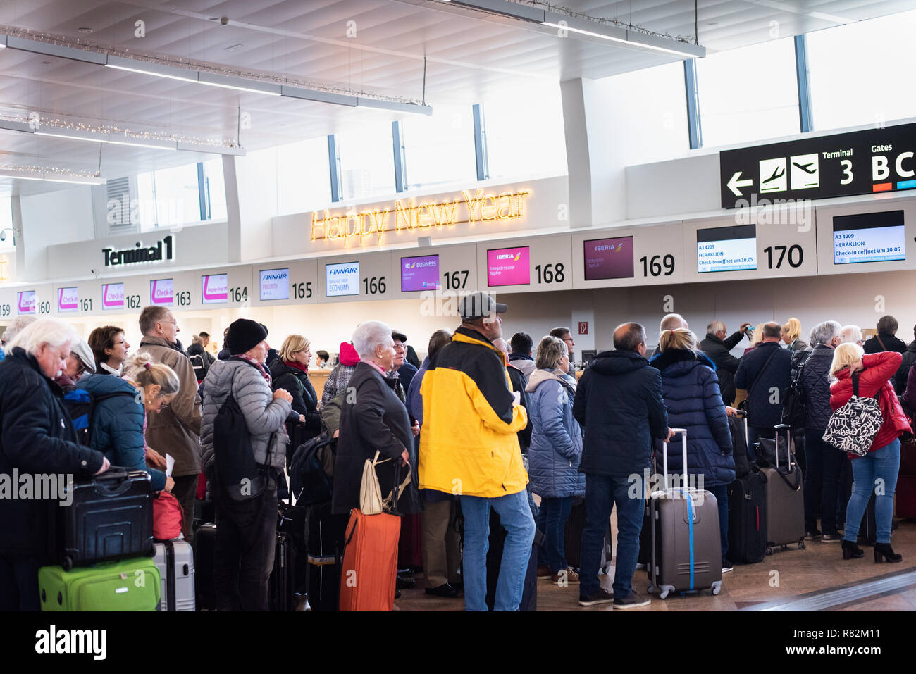 Long check in queues at airport with a Happy New Year sign in ...