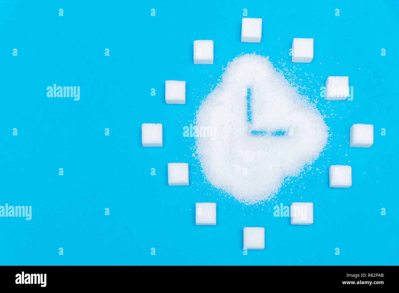 Sugar cubes in a clock layout position on a blue background. World ...