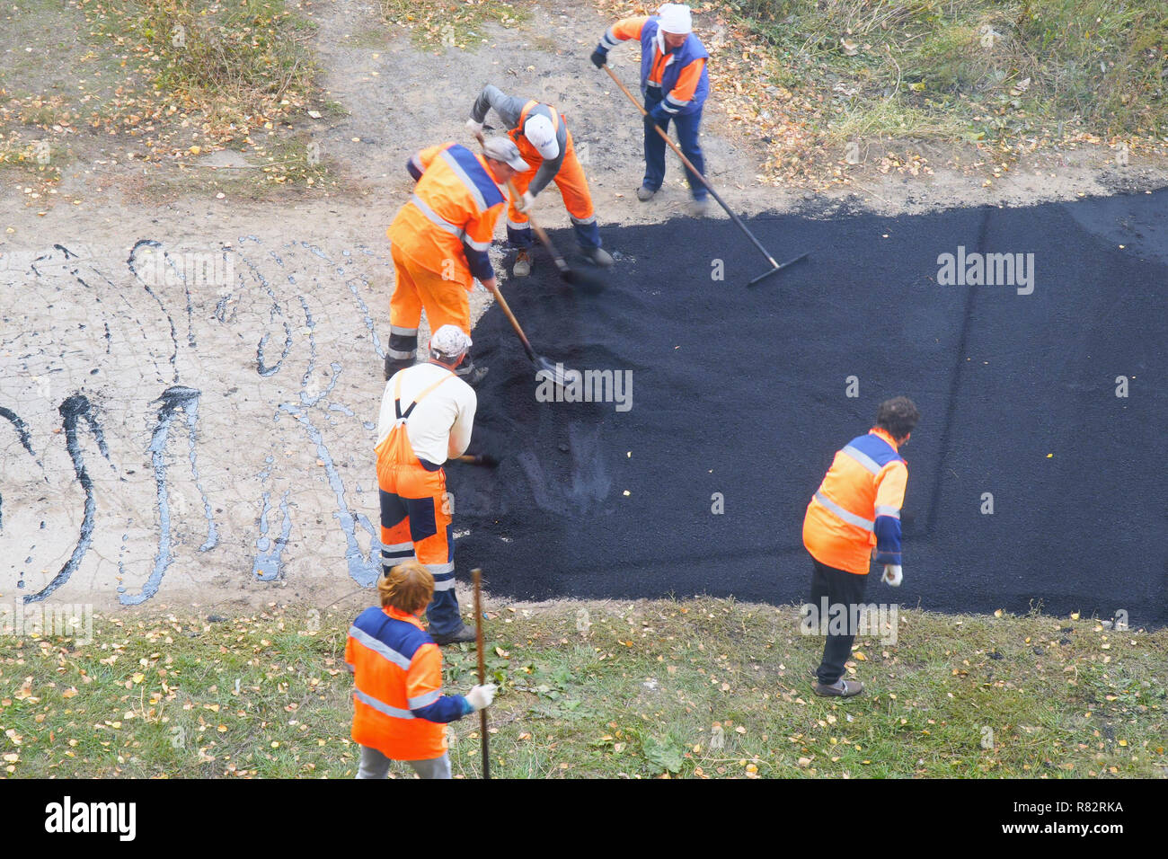 Road street repairing works. Construction workers during asphalting ...
