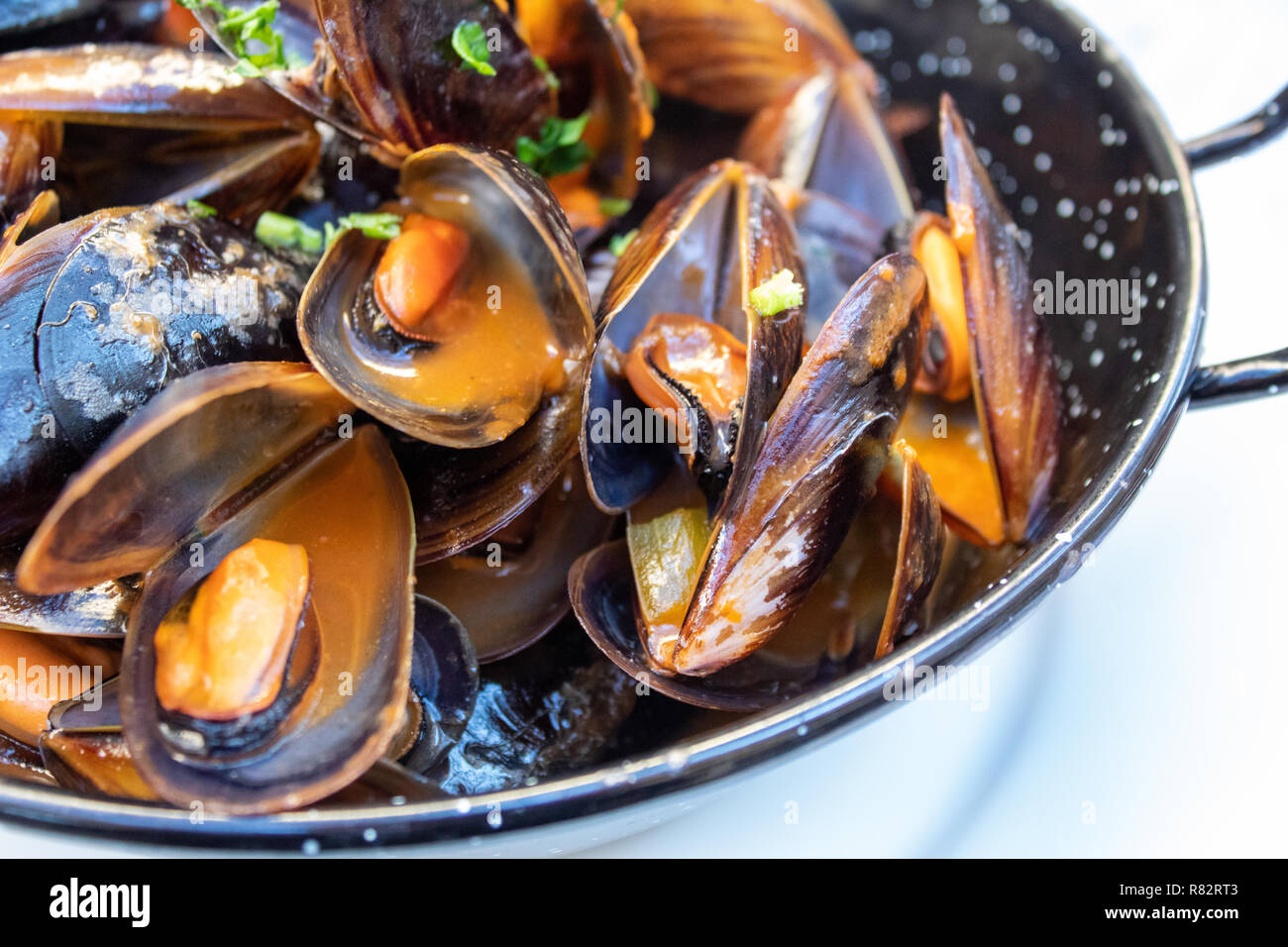 Mussels in tomato sauce served in frying pan Stock Photo - Alamy