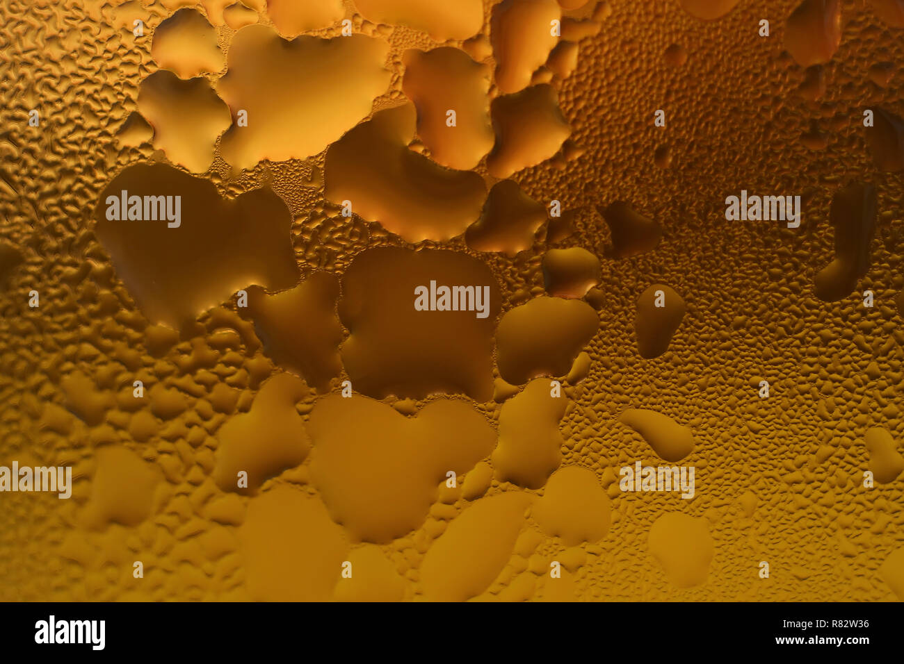 Various patterns of condensation on the glass full of amber color ...