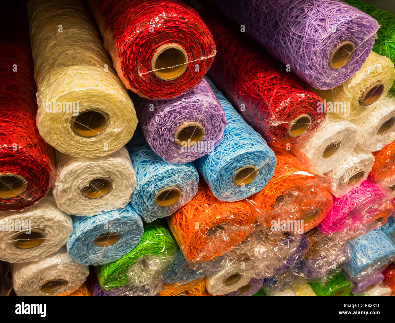 Rolls of textured decorative wrapping paper of different colors on the ...