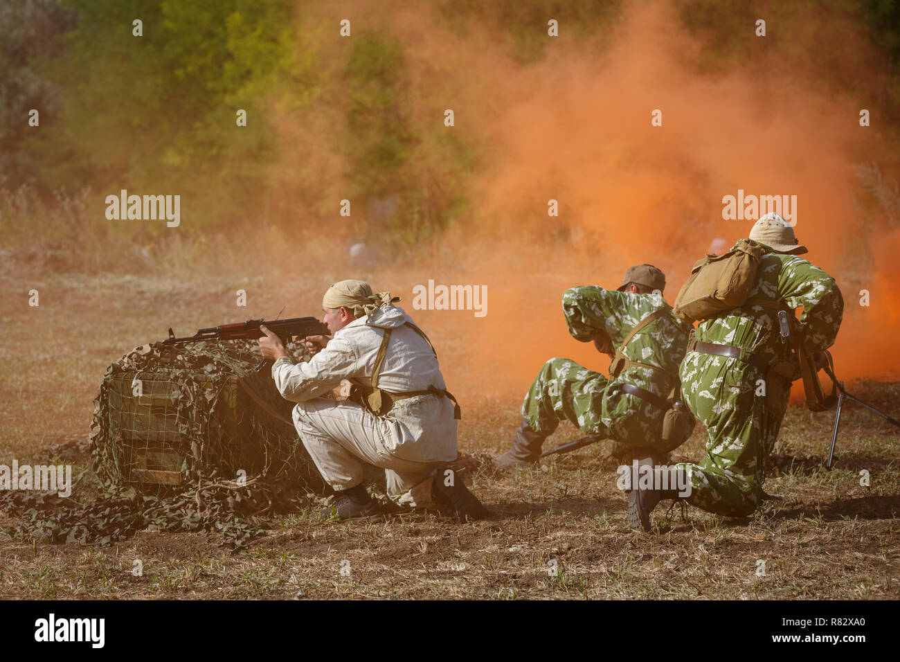 Three Soviet soldiers retreat from the battlefield using a smoke Stock ...