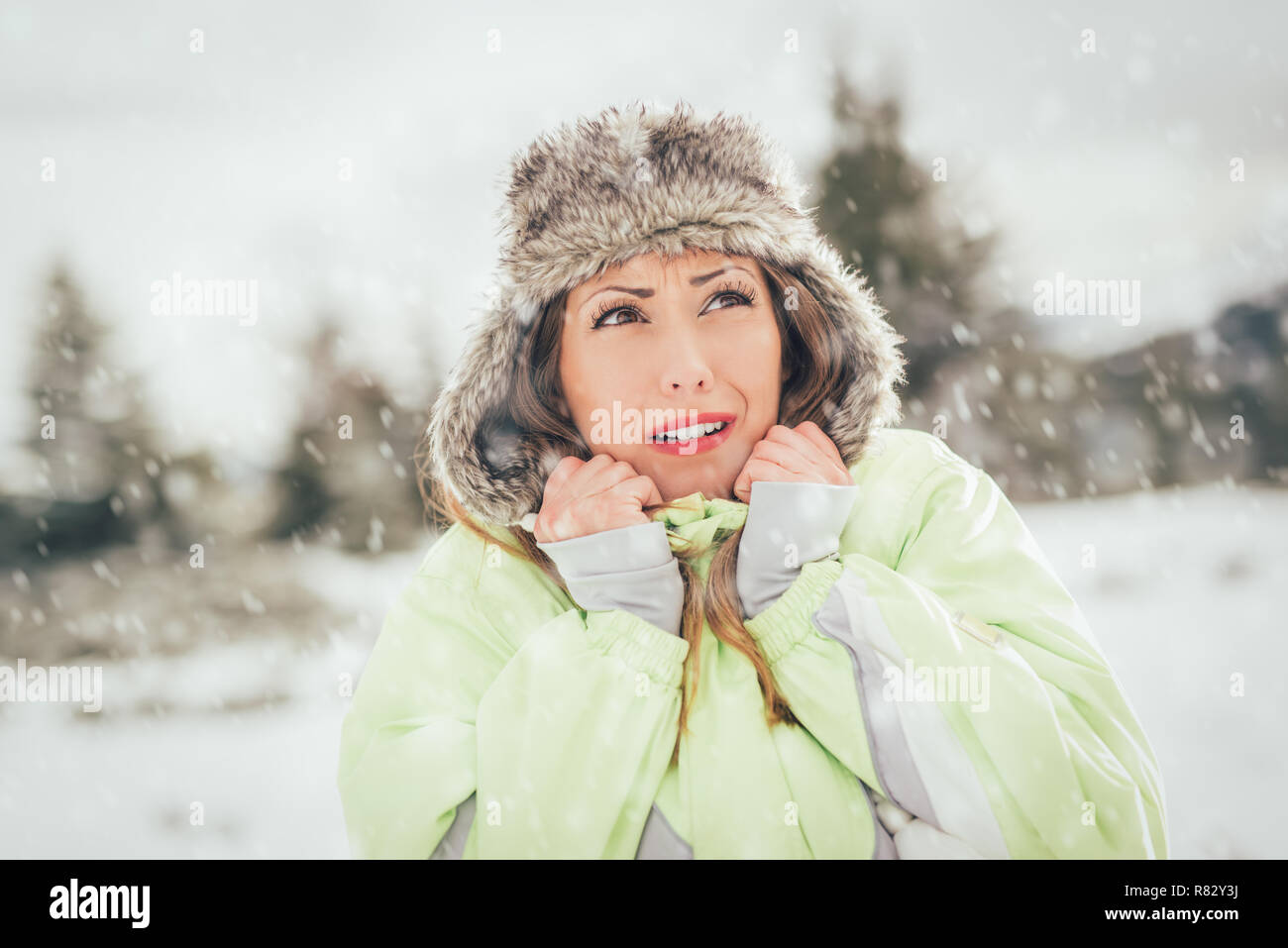 Beautiful young frozen woman skier in winter vacations, standing and ...
