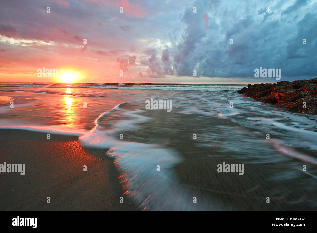 Beautiful sunrise by the rocks wand waves of Folly Beach South Carolina ...
