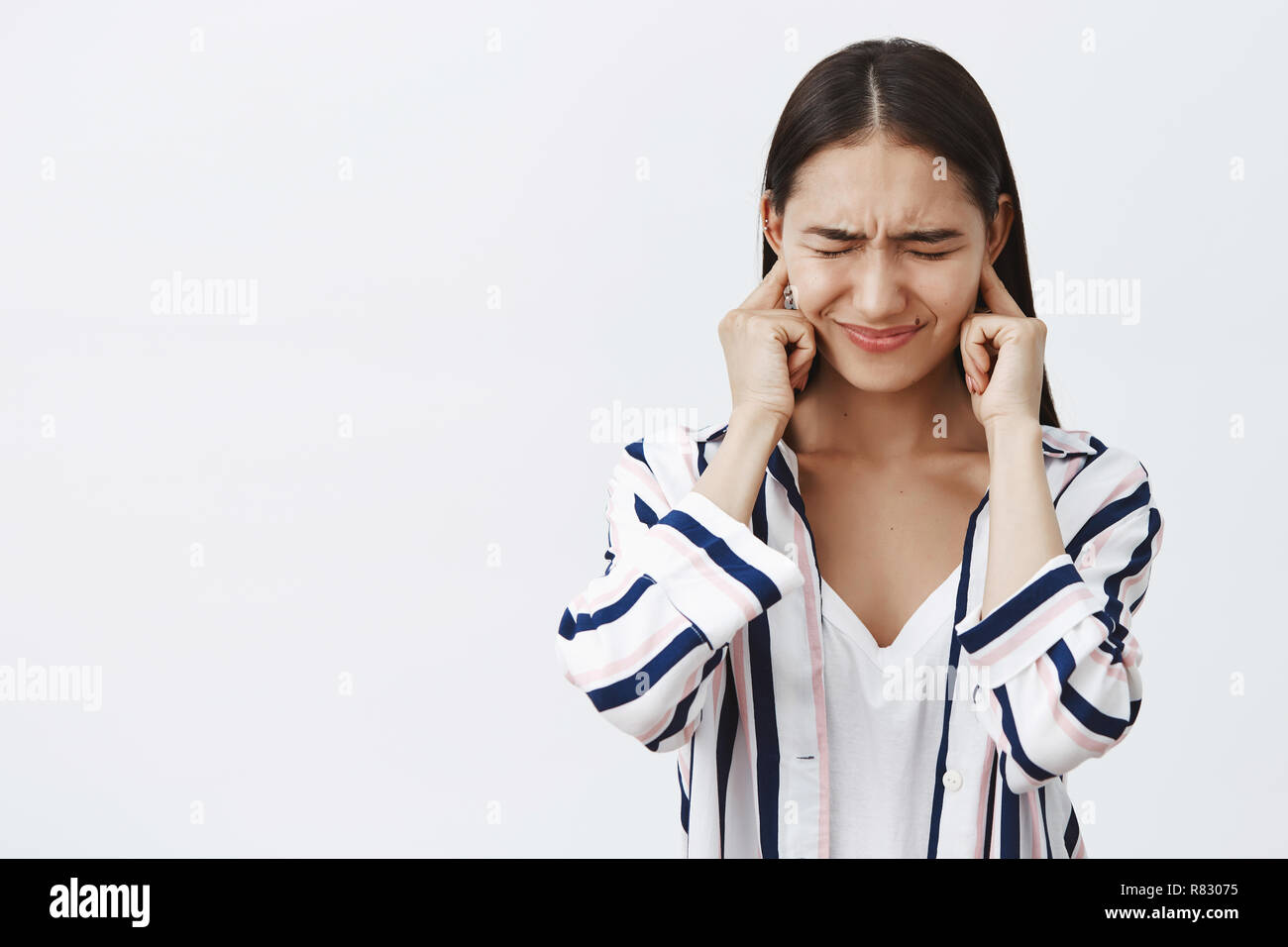 Daughter covering ears being displeased of loud fight of parents ...