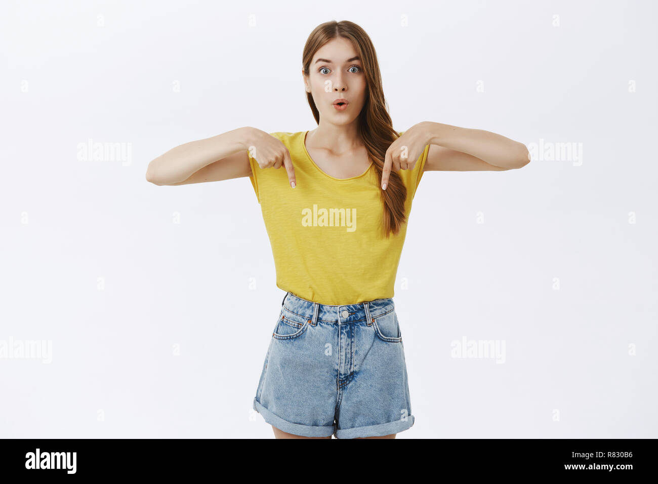 Woman amazed with awesome comfortable sneakers pointing downwards ...