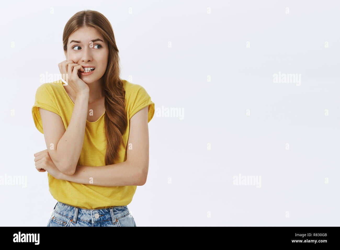 Portrait of silly scared cute girl with bad habit biting fingers from ...