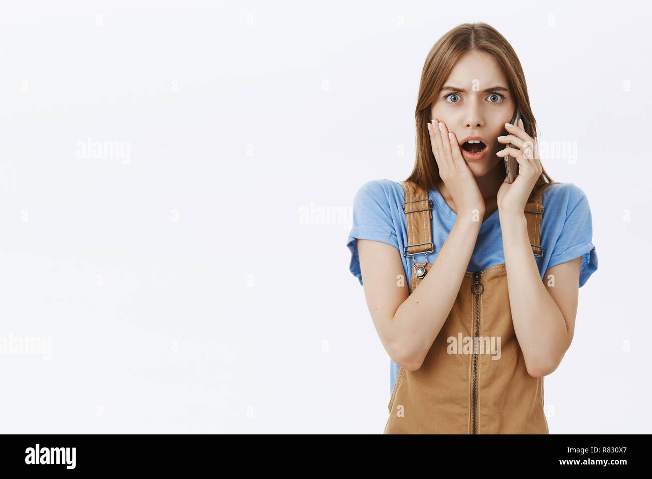 Woman receiving phone call from friend being shocked and stunned with ...