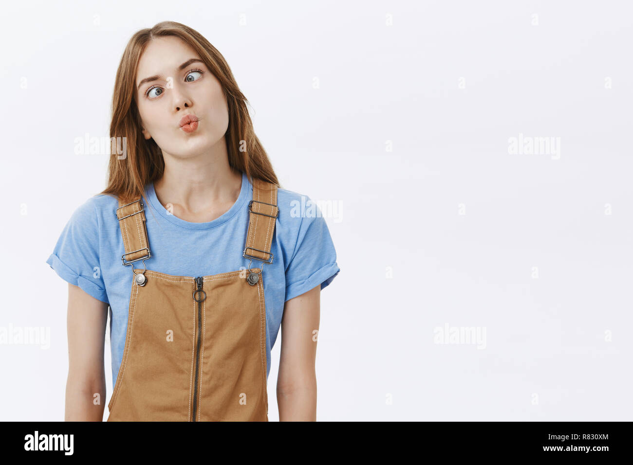 Waist-up shot of playful charming cute girl fooling around folding lips ...