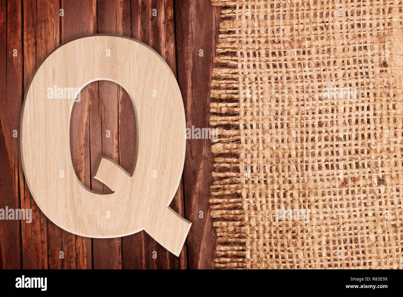 Wooden alphabet letter symbol - Q. On wooden table background wih ...