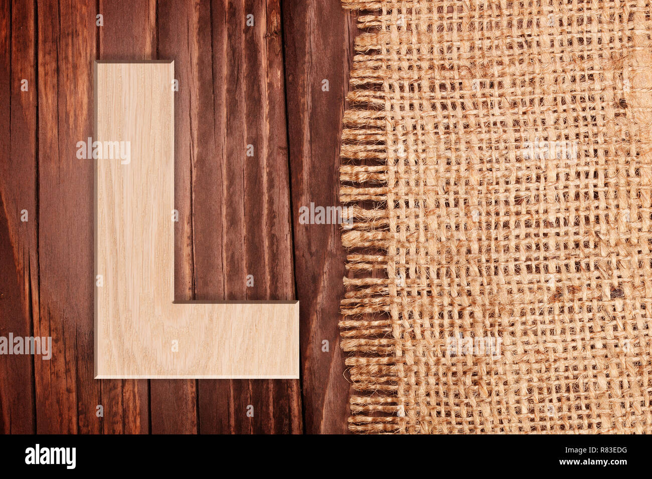 Wooden alphabet letter symbol - L. On wooden table background wih ...