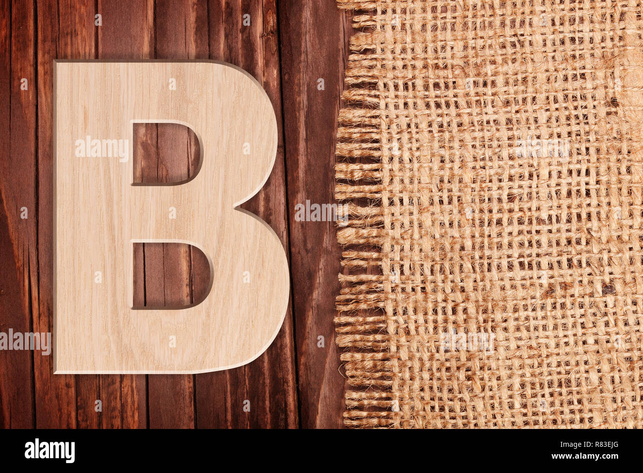 Wooden alphabet letter symbol - B. On wooden table background wih ...
